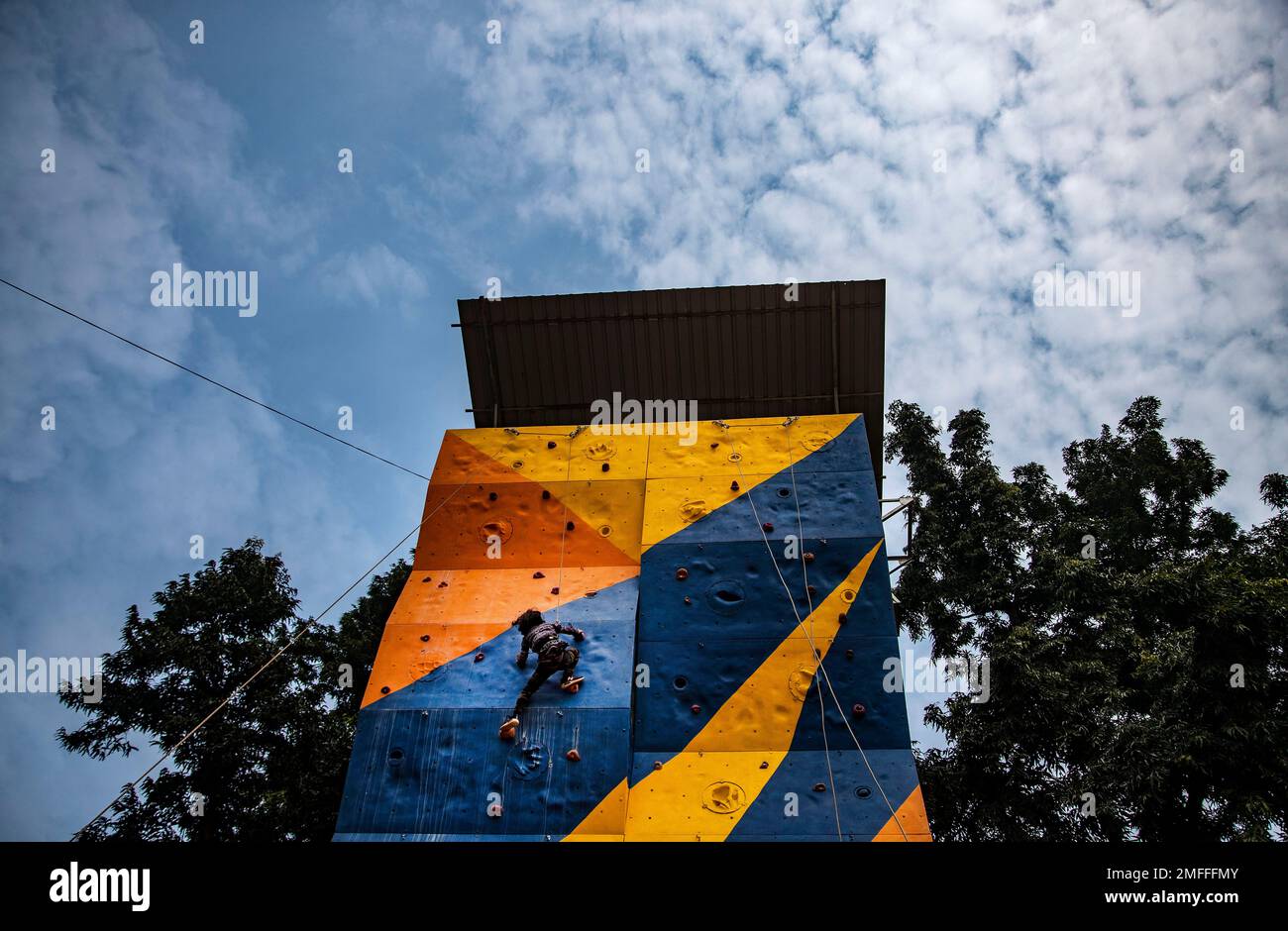 A boy climbs an artificial wall during a two-day-long sports climbing ...