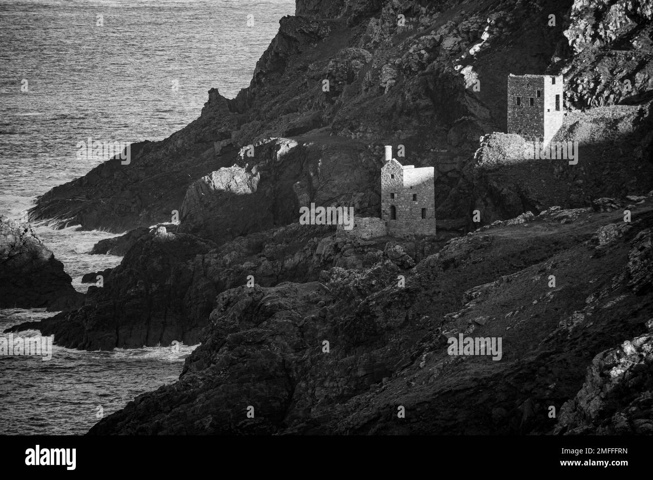 Mining engine houses on cliffs at Botallack, Cornwall, black and white ...
