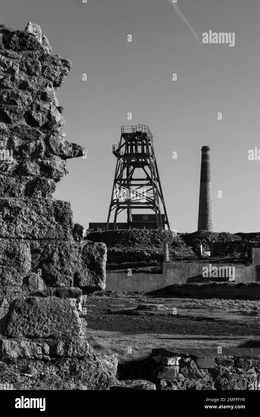 Wall in foreground with mining equipment in background, black and white ...