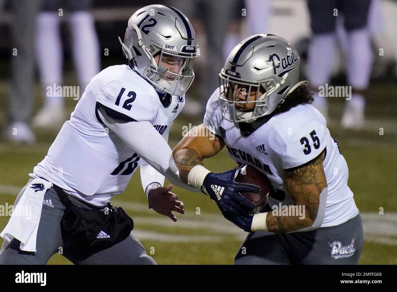 Nevada quarterback Carson Strong (12) hands off the ball to running ...
