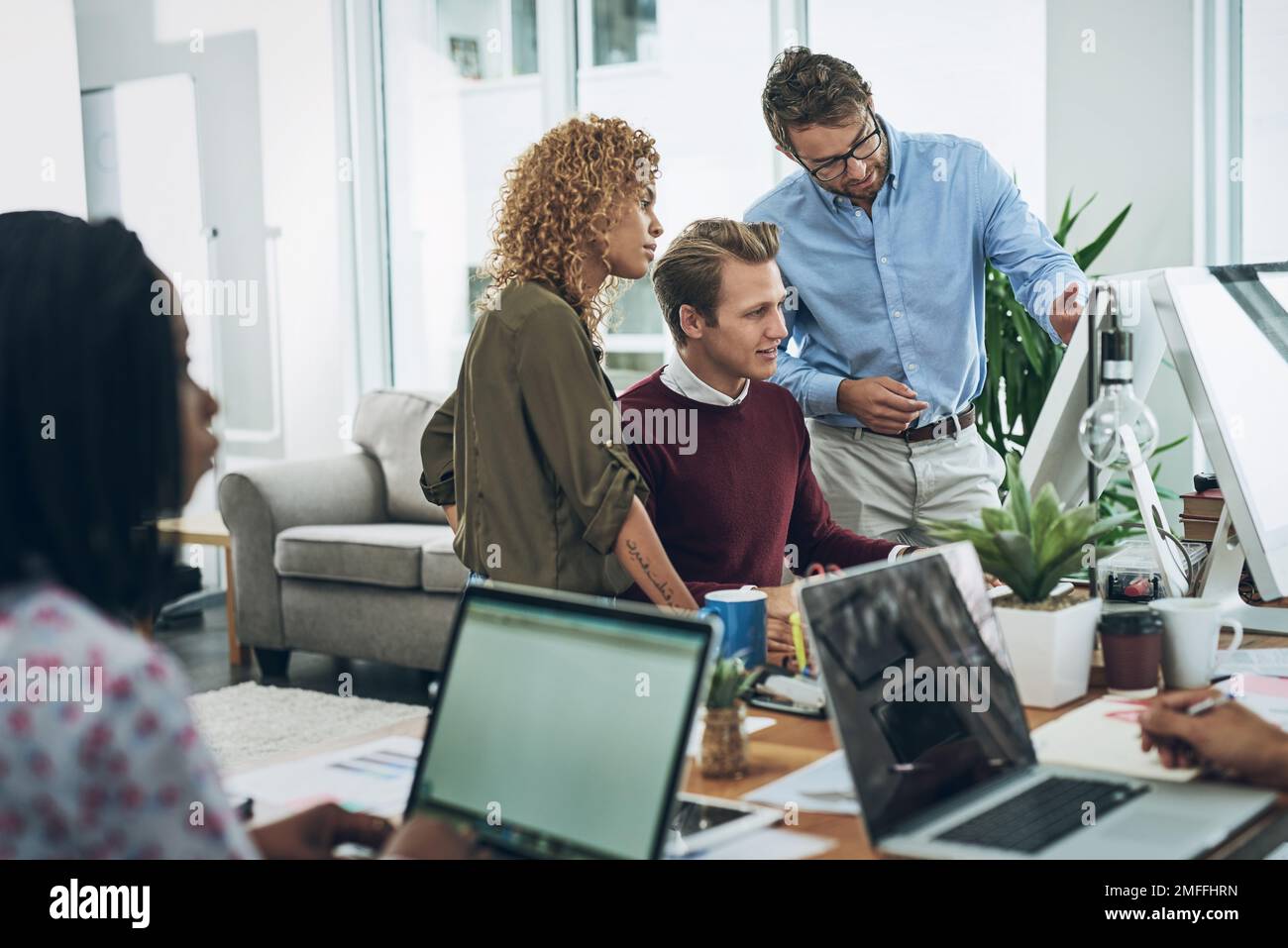 The connected team is an efficient team. a group of colleagues using a ...