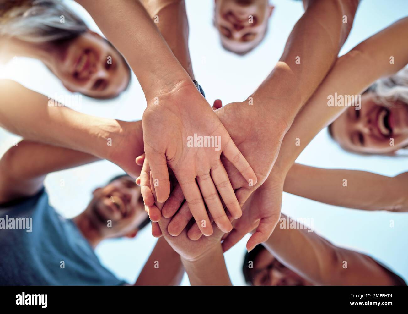 Together forever. Low angle shot of a young group of friends standing ...