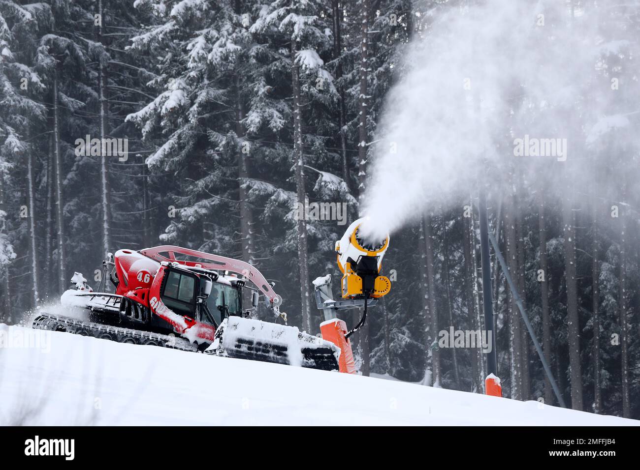 A snow cat passes a snow maker at a ski slope in Igls, near Innsbruck ...