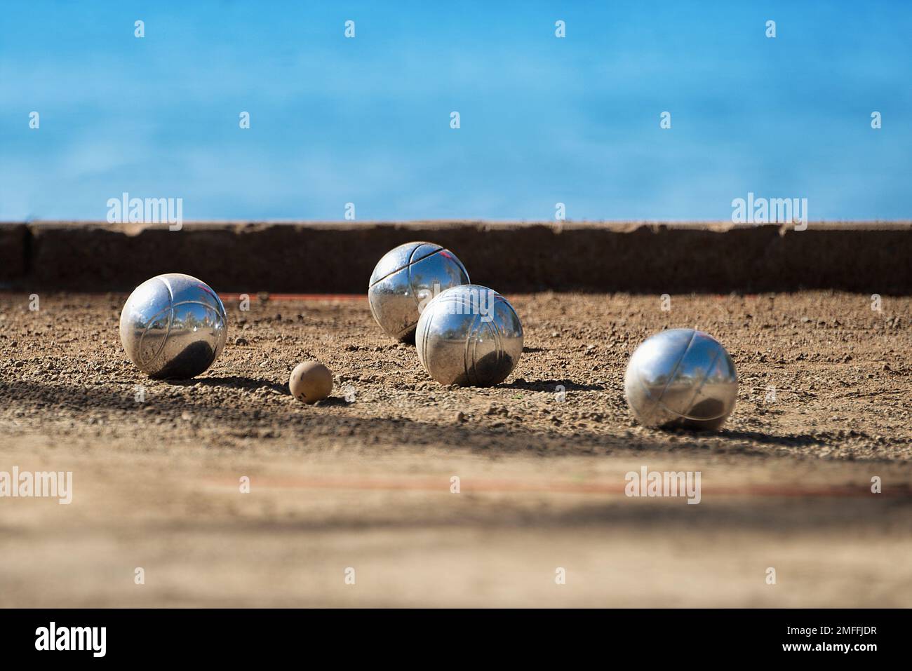 Metallic petanque four balls and a small wood jack Stock Photo - Alamy