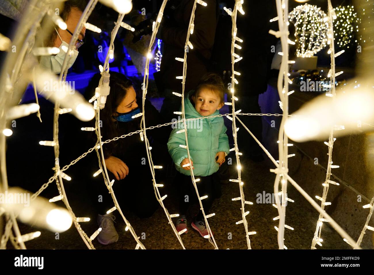 A mother watches as her young daughter delights in looking through a ...