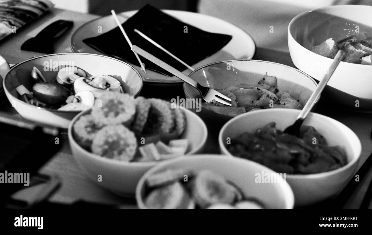 A monochrome shot of different delicious meals on the restaurant table ...