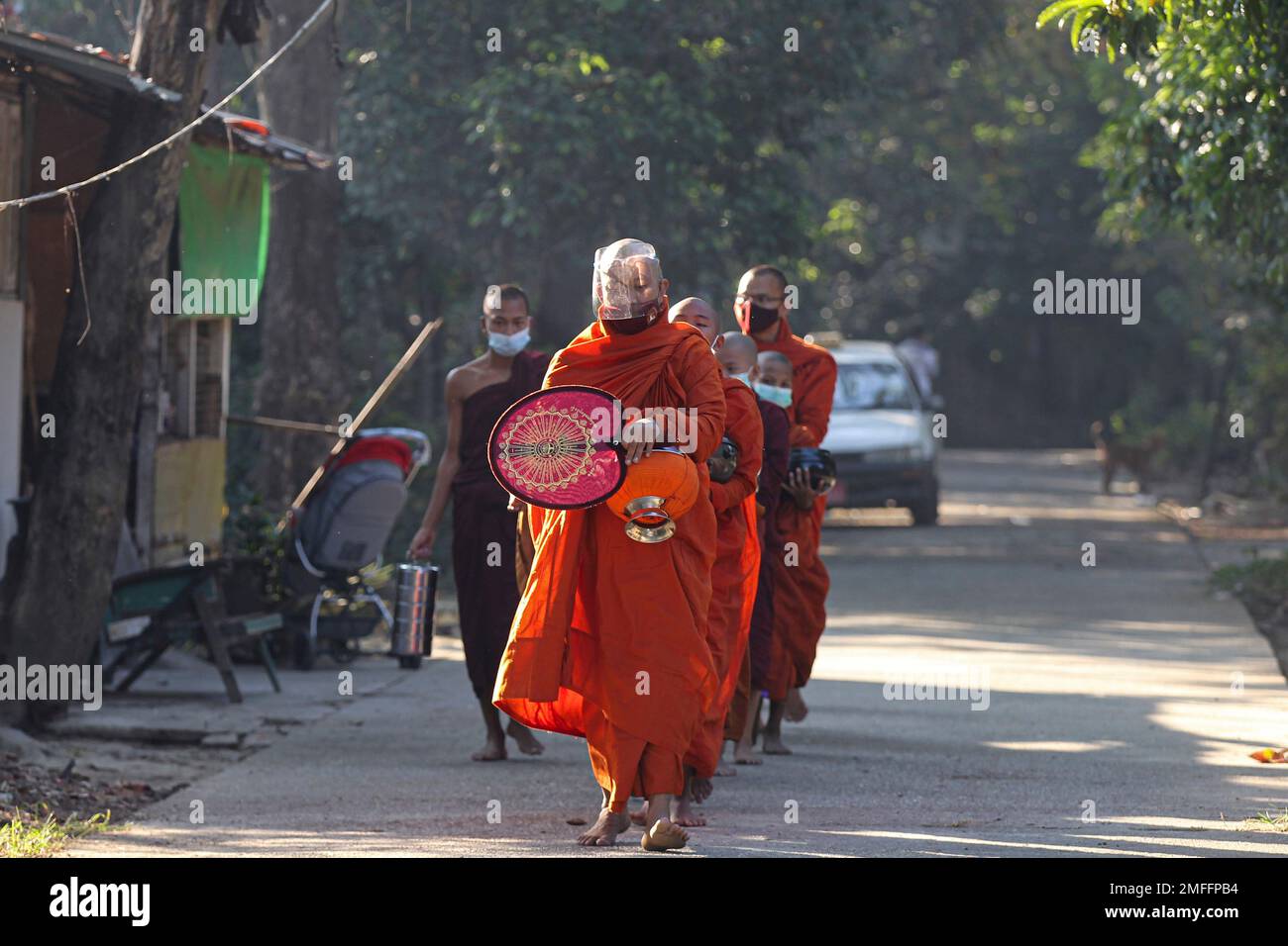 Buddhist monks wearing a face shield and masks to help curb the spread ...