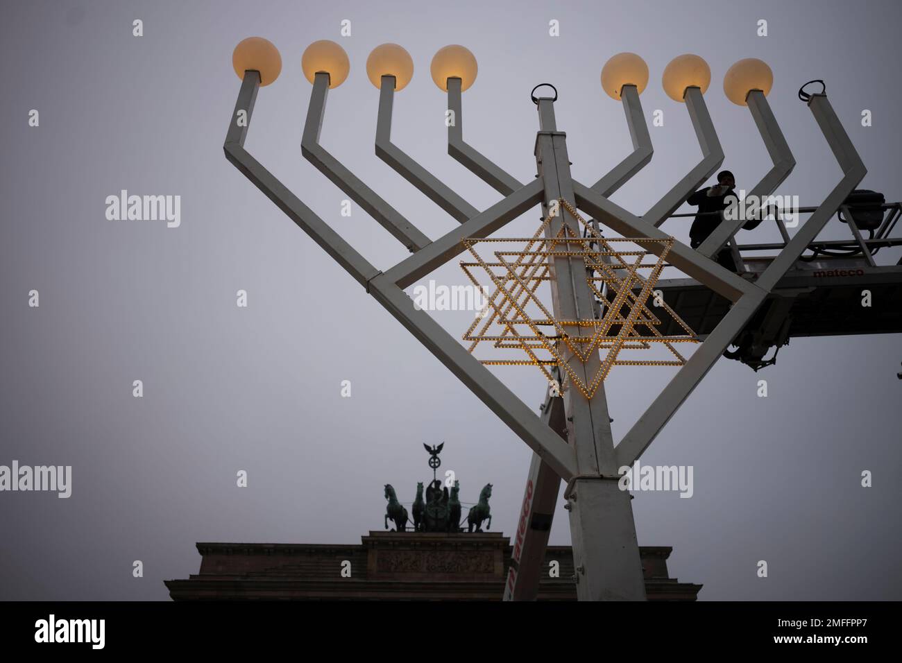 A man cleans a giant Hanukkah Menorah, set up by the Jewish Chabad ...