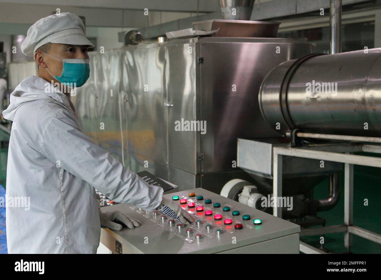An employee of the Pyongyang Corn Processing Factory watches over the ...