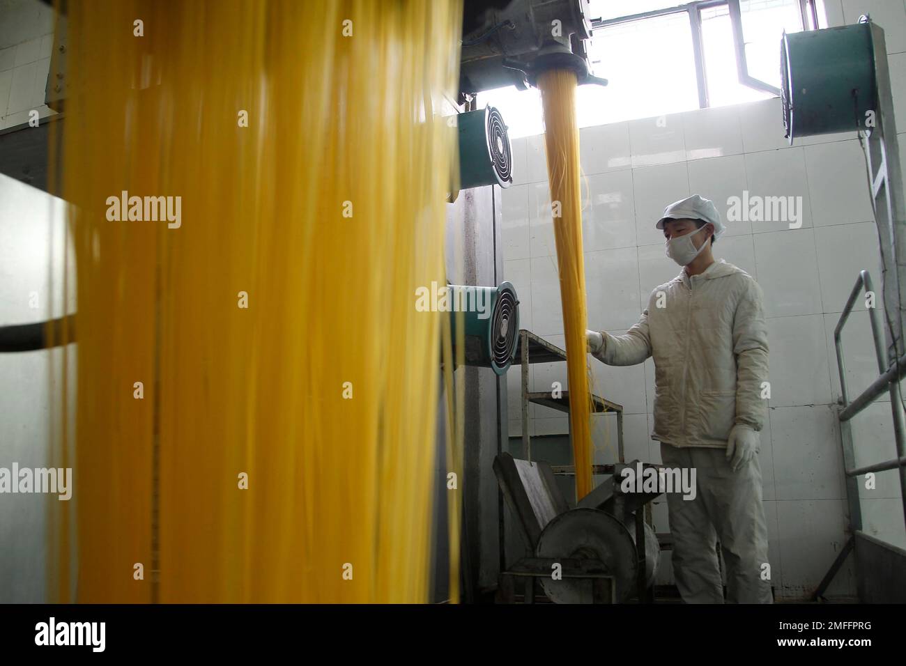 An employee of the Pyongyang Corn Processing Factory watches corn ...