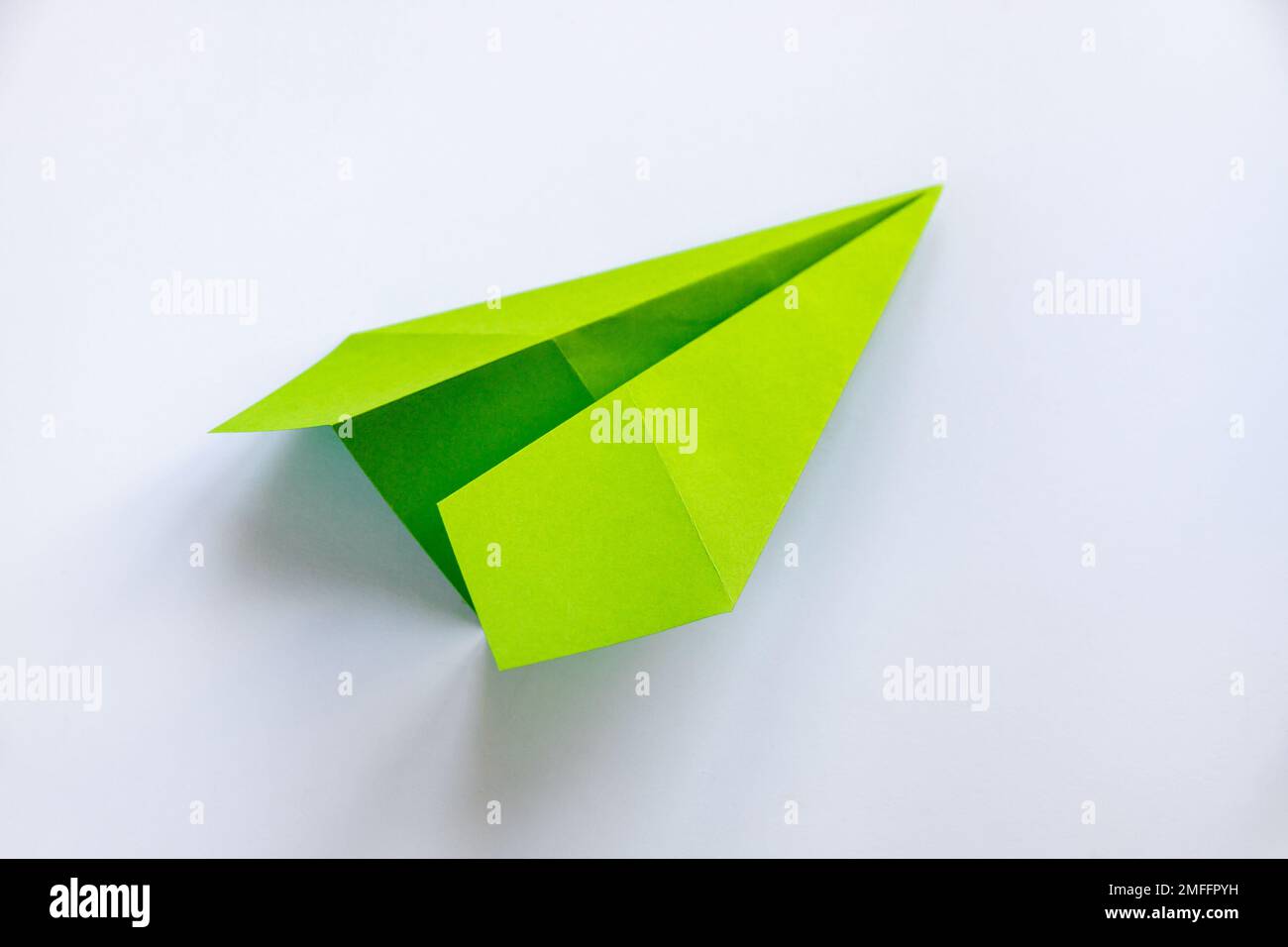 Green paper plane origami isolated on a blank white background Stock ...