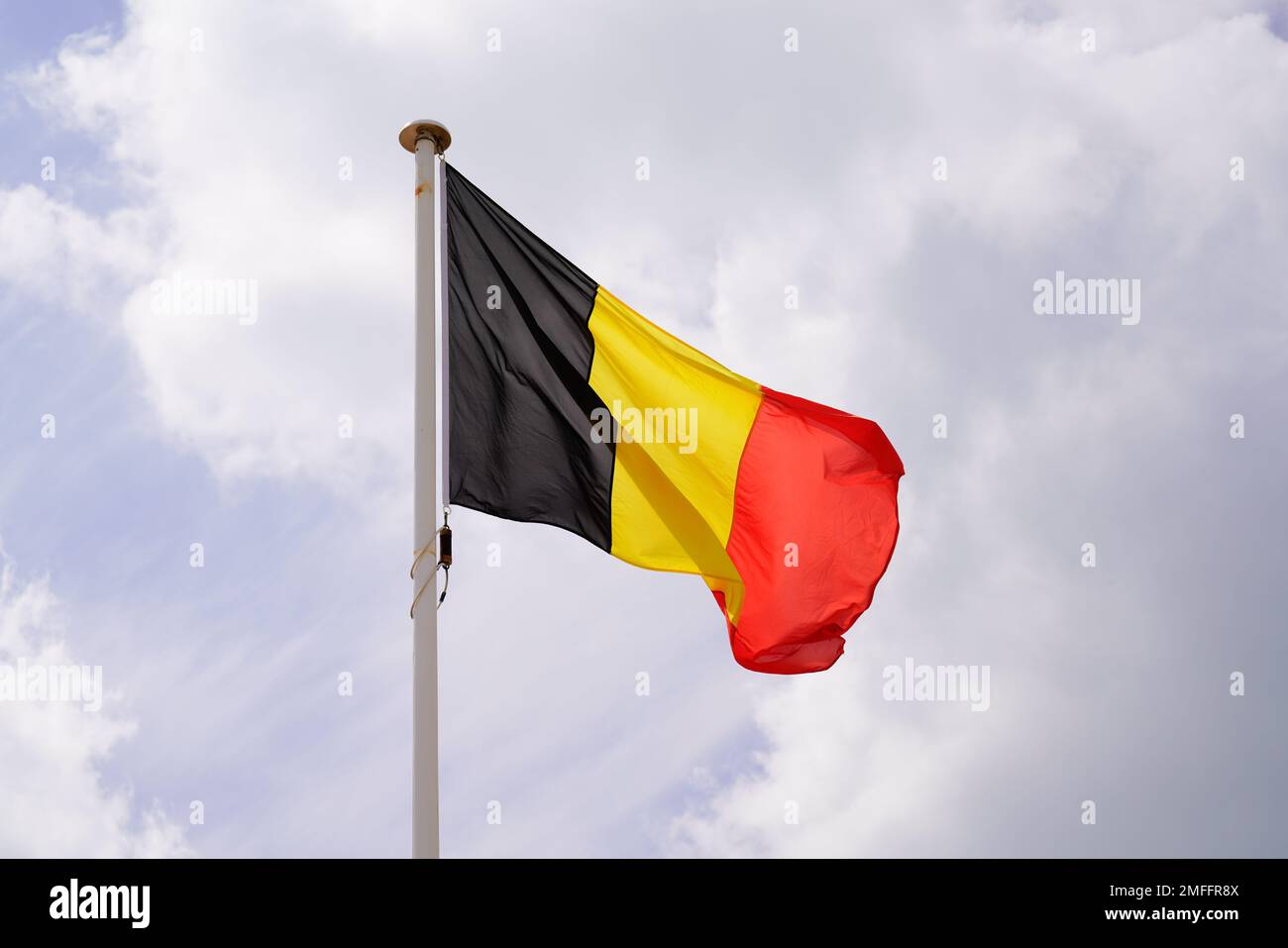 belgium flag belgian wave over a cloudy sky Stock Photo - Alamy
