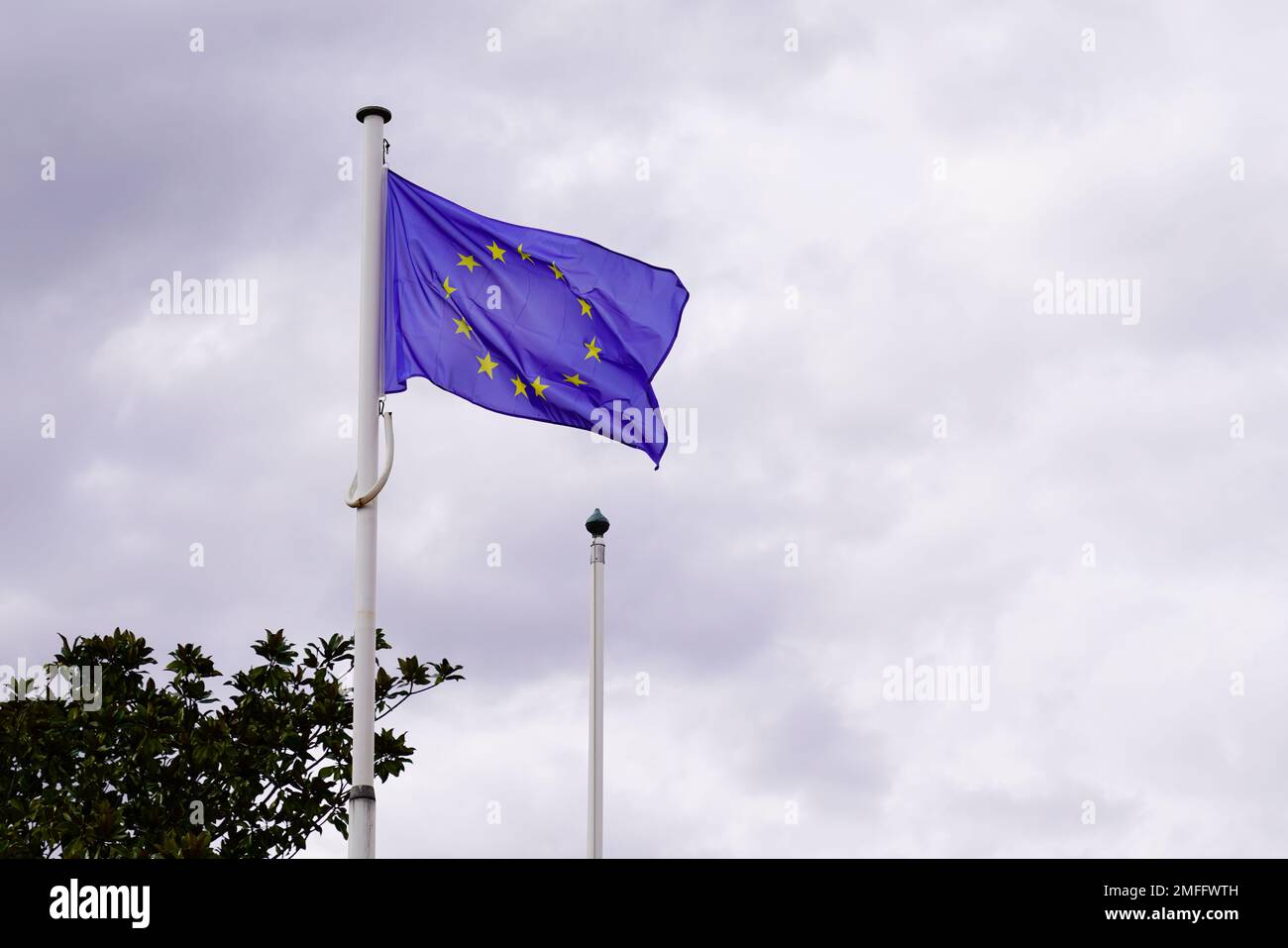 blue flag of European Union EU in cloud sky in mast Stock Photo - Alamy
