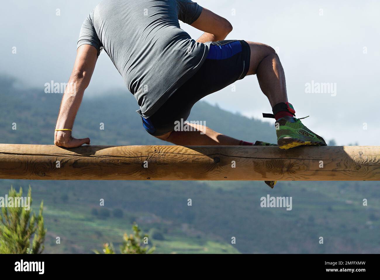 Running over obstacles male race participant, extreme sport Stock Photo ...