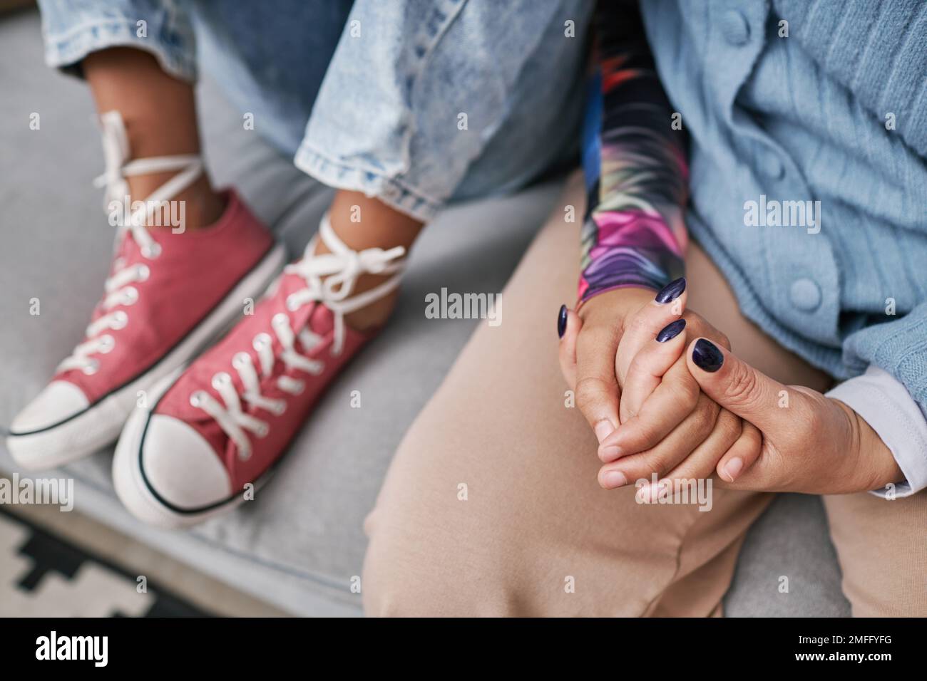 Close up of depressed teenage child crying with mother or therapist ...