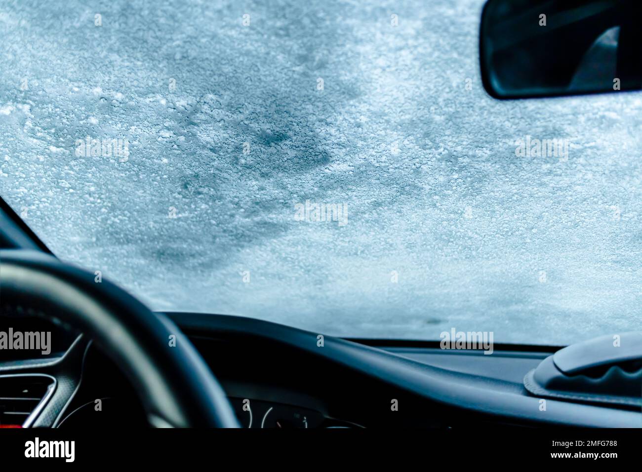 Frozen car windshield covered with ice and snow on a winter day ...