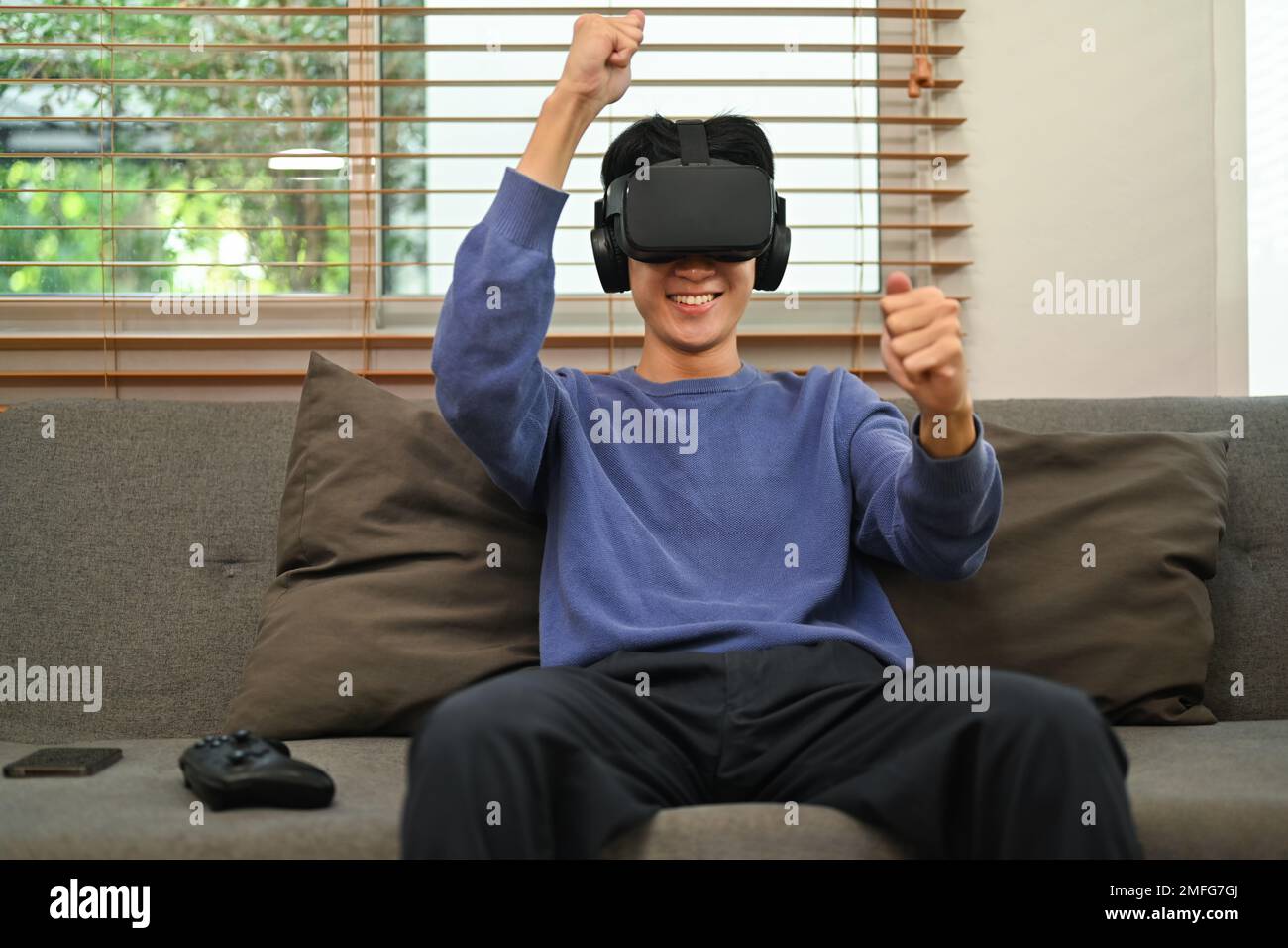 Excited man in boxing stance playing action simulator game, fighting ...