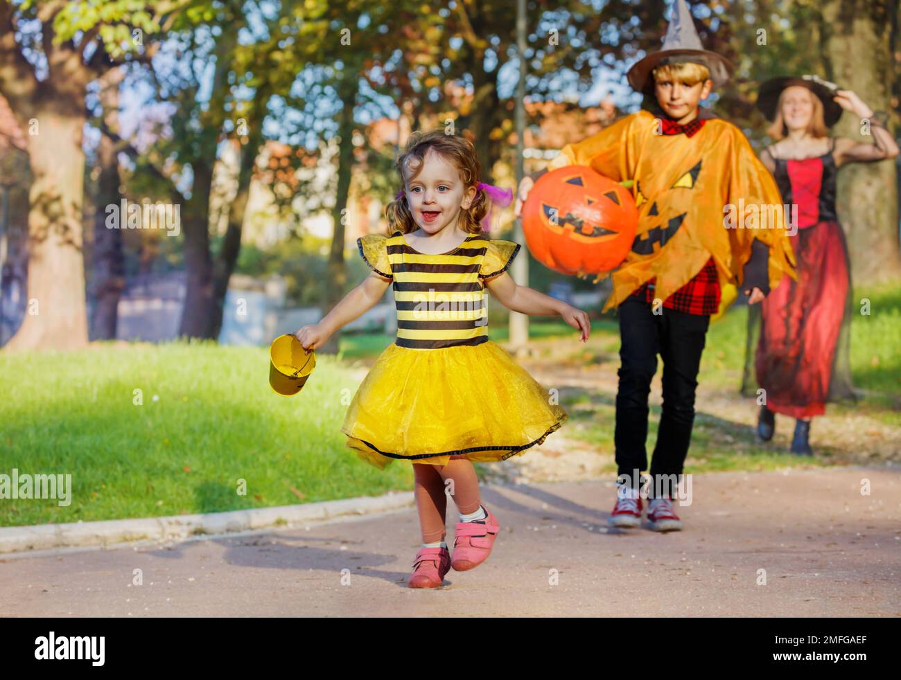 Happy girl with mother and brother run holding Halloween bucket Stock ...
