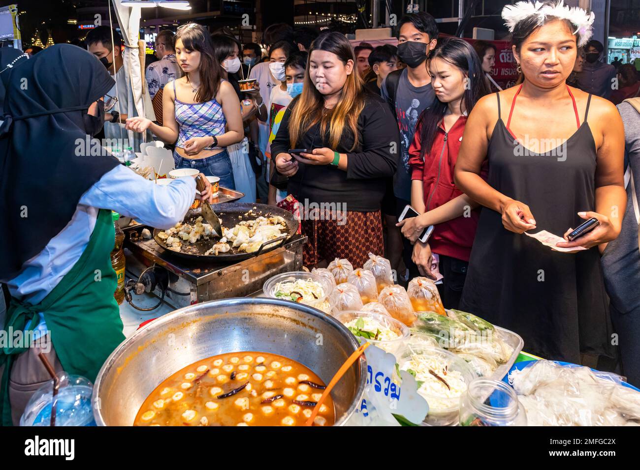 Food vendors and customers at street market at night in Pattaya ...
