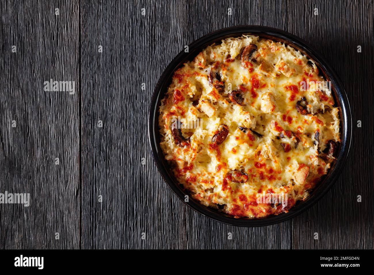 Delicious Chicken Mushroom Rice Casserole in baking dish on dark wood ...