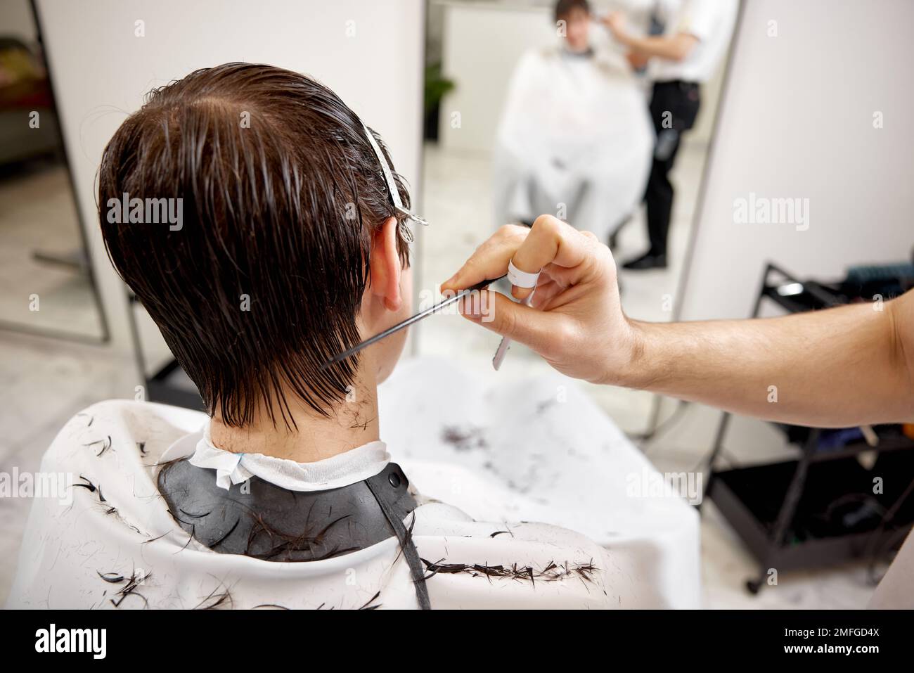young caucasian man getting haircut by professional male hairstylist ...