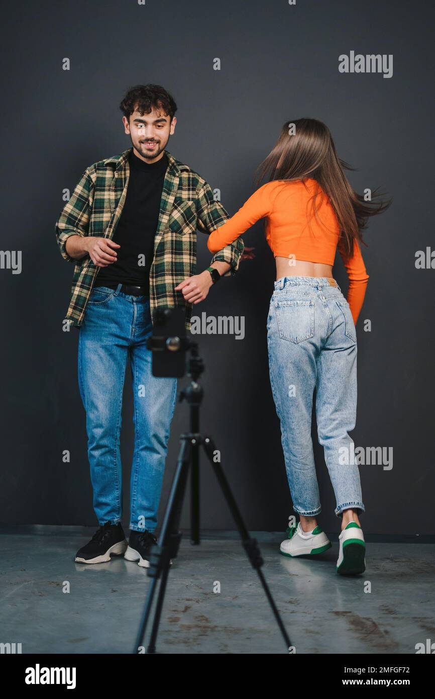 Millennial couple recording video, having fun, dancing while filming ...