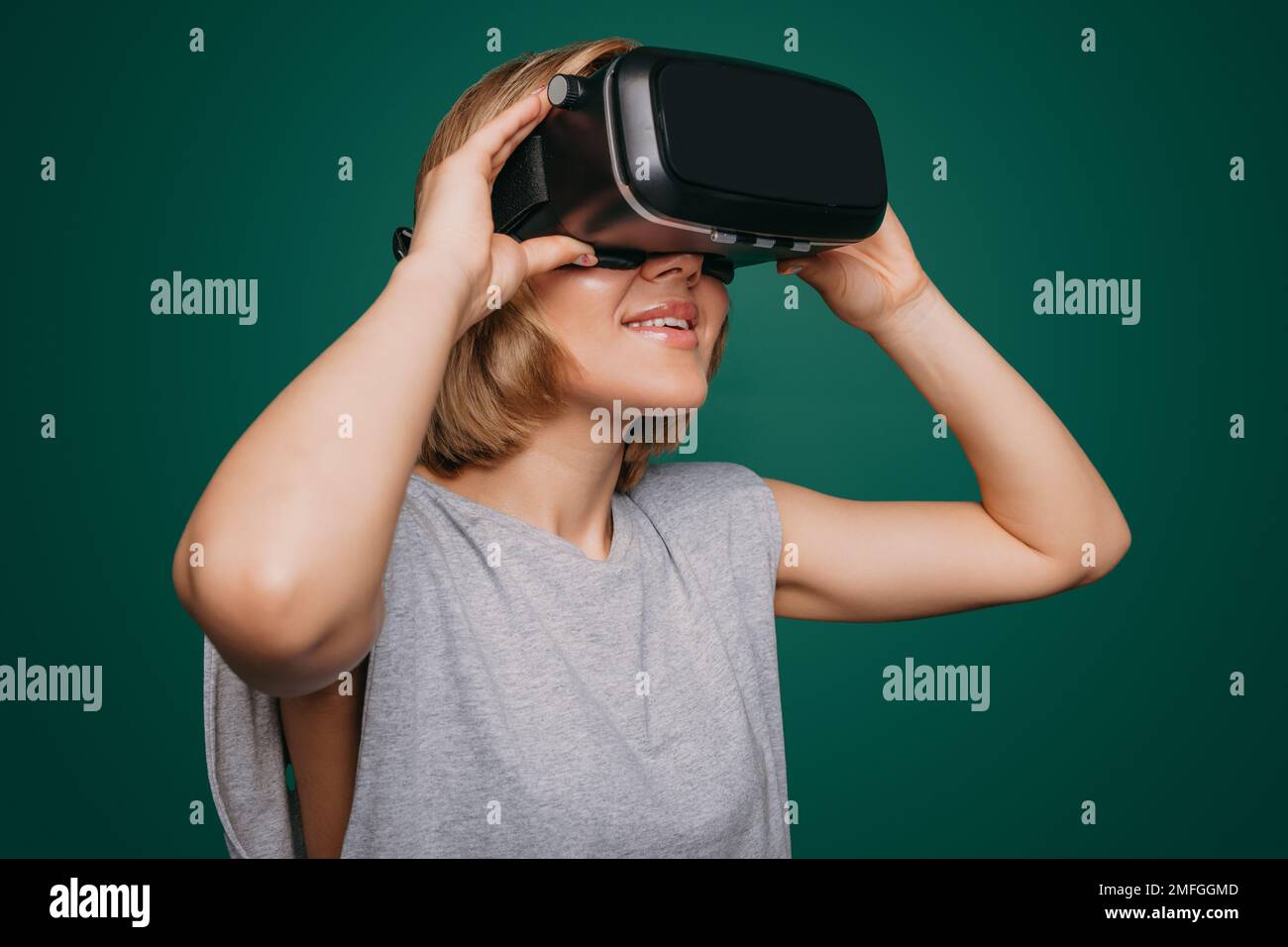 Happy excited blonde woman enjoying VR experience wearing virtual ...