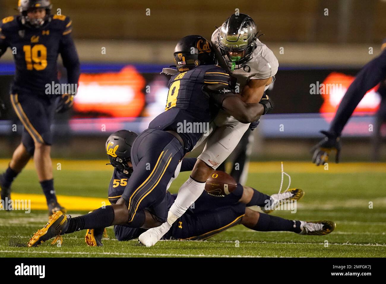 Oregon wide receiver Johnny Johnson III, center right, fumbles the ball ...
