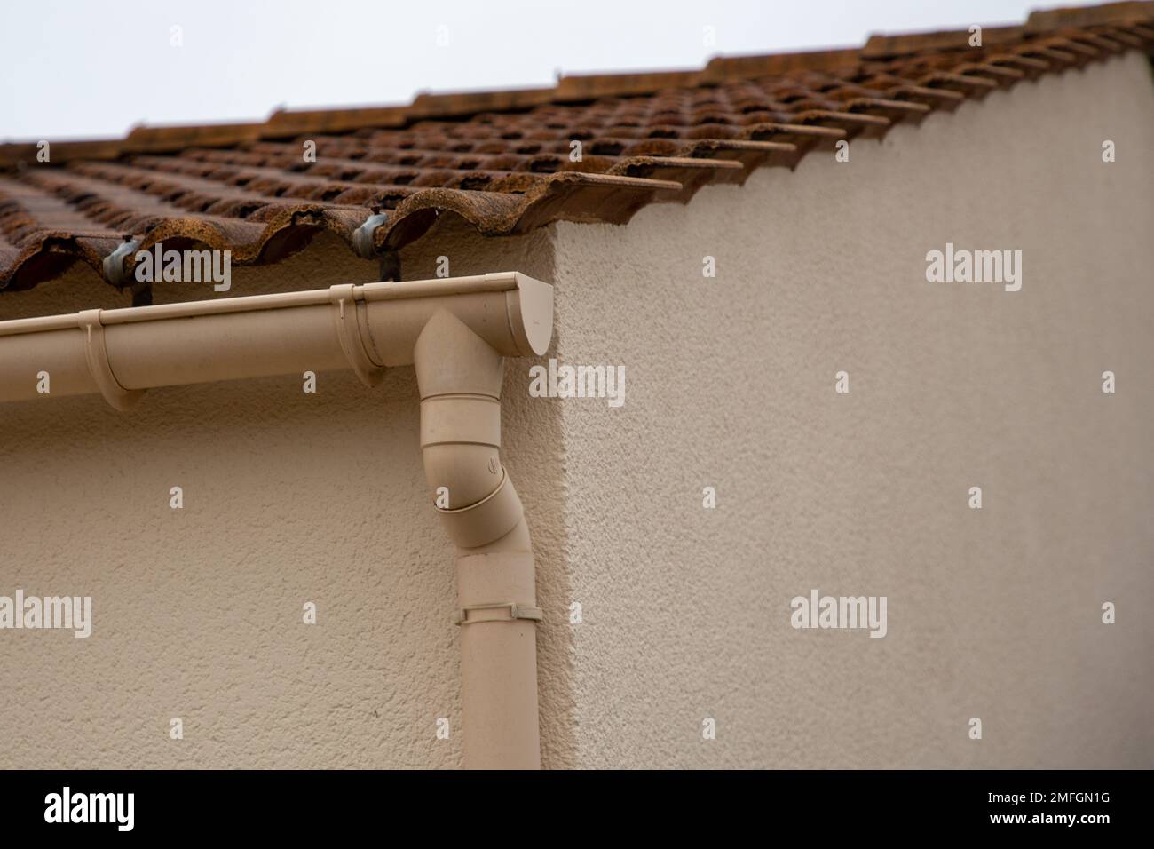 plastic edge of a roof gutter with clips and edge of shingles Stock ...