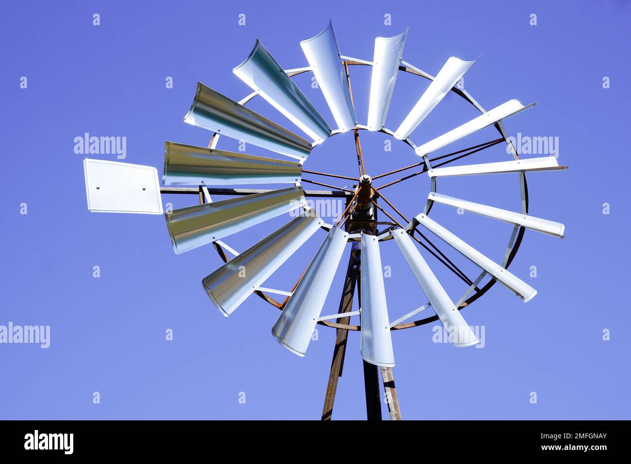Small Rustic Windmill vintage wind turbine in blue sky Stock Photo - Alamy