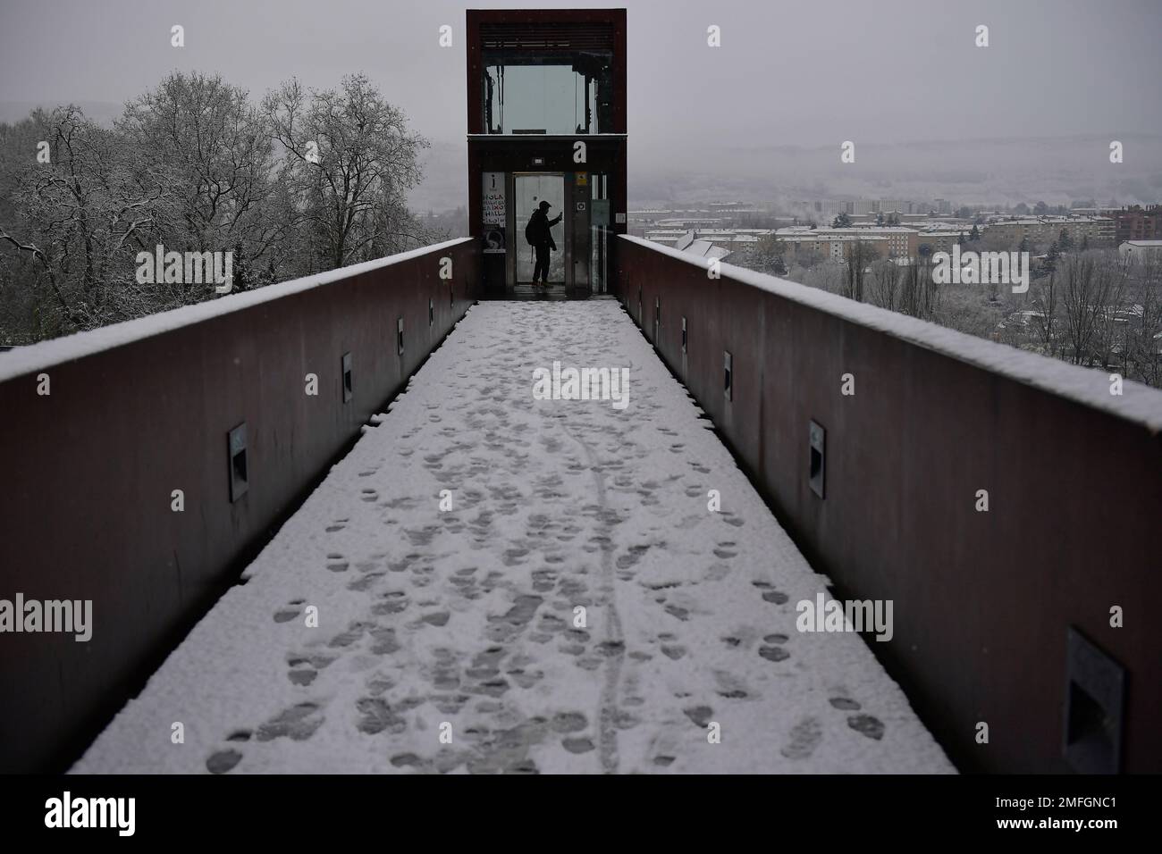 A resident takes a lift as the snow falls in the city, in Pamplona ...