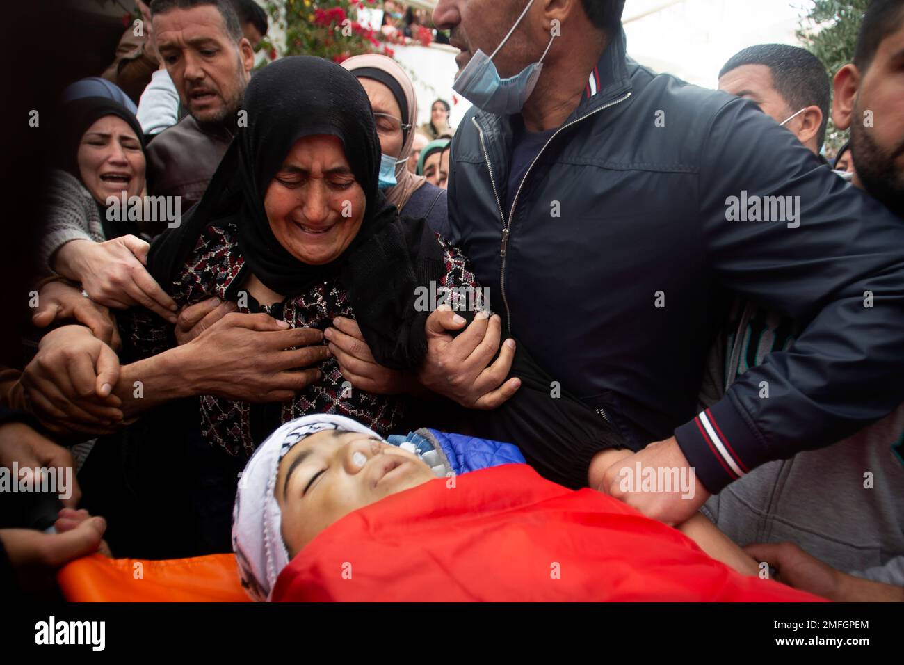 Relatives mourn the body of a 13-year-old Ali Abu Alia who was shot ...