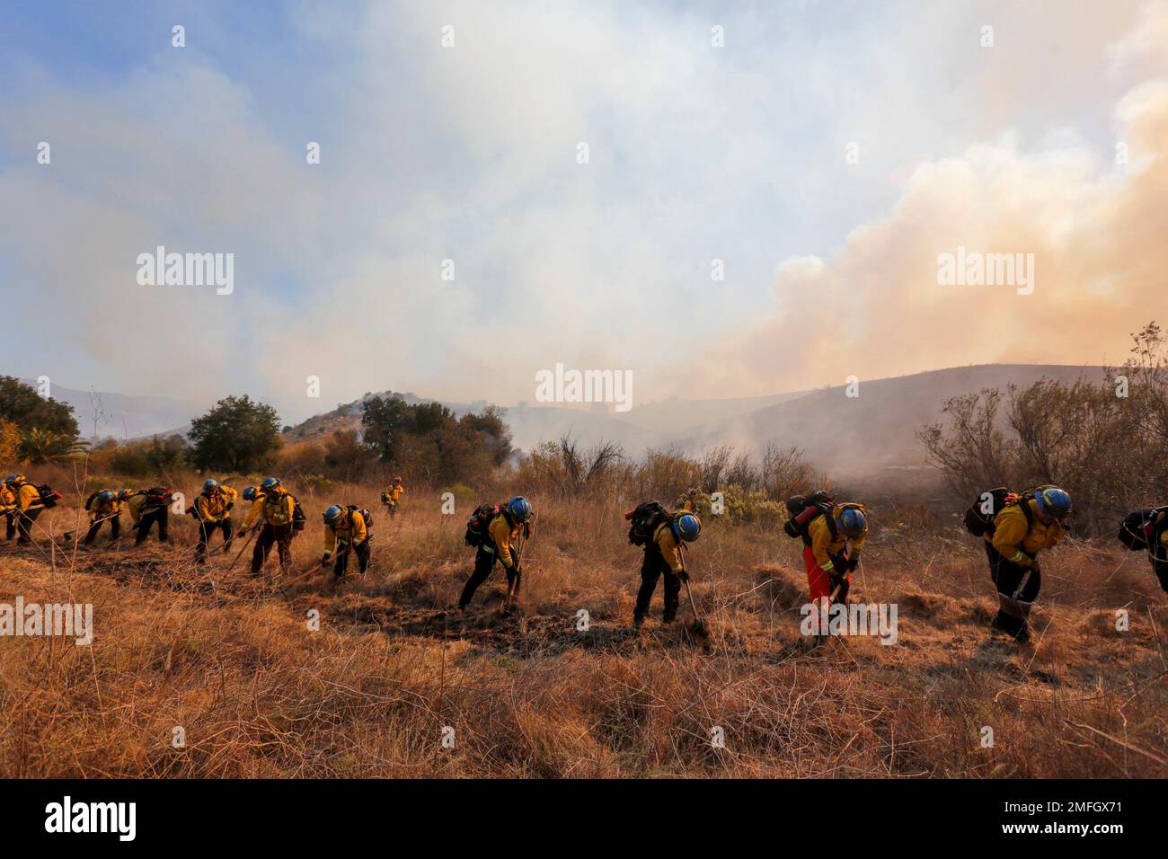 A hotshot hand crew works on a fireline while the Bond Fire burning in ...