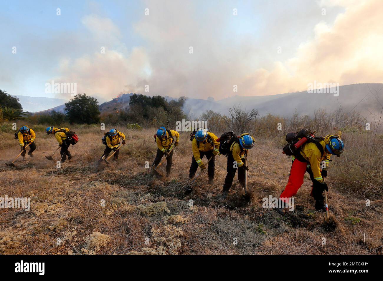 A hotshot hand crew works on a fireline while the Bond Fire burning in ...