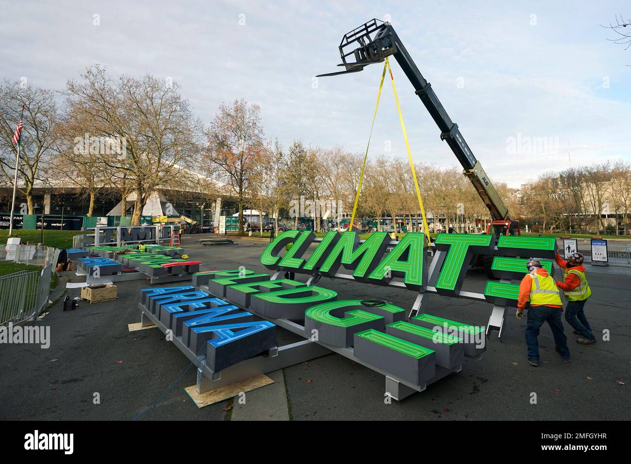 Workers assemble signs for the top of Climate Pledge Arena (shown in ...