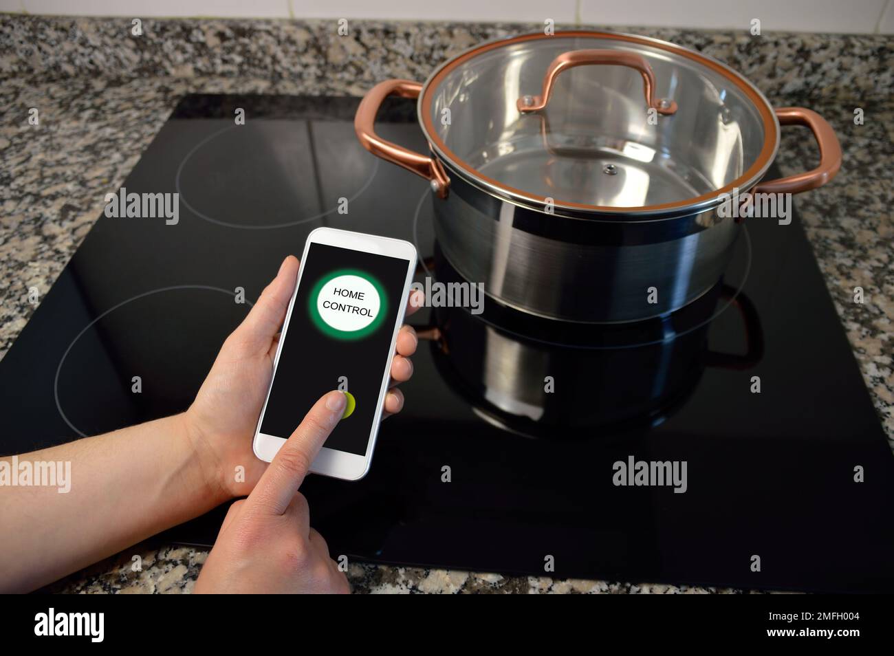 Man hand holding mobile phone smart control home cooker at kitchen.Home ...