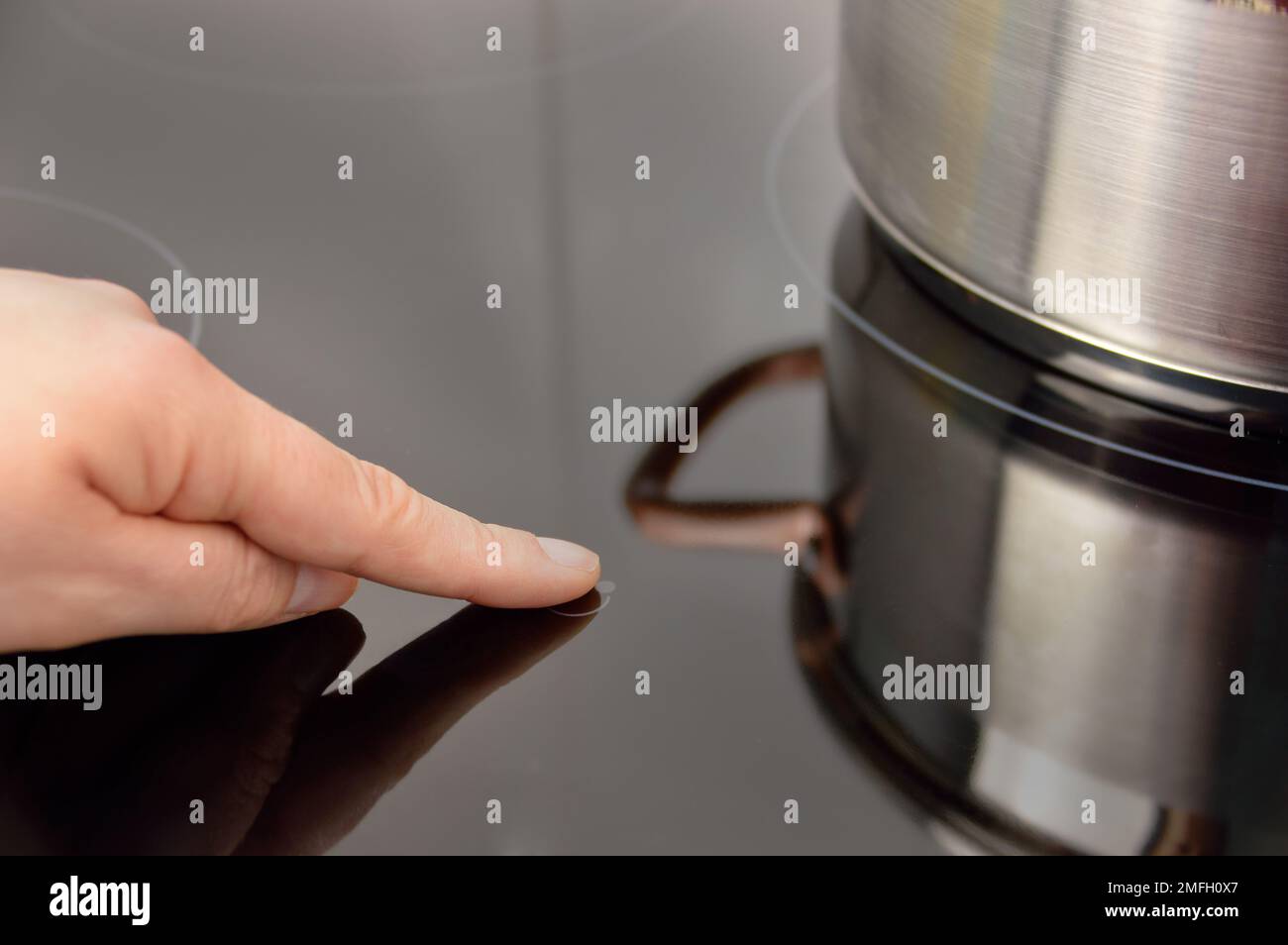 Woman select function on Induction stove Stock Photo - Alamy