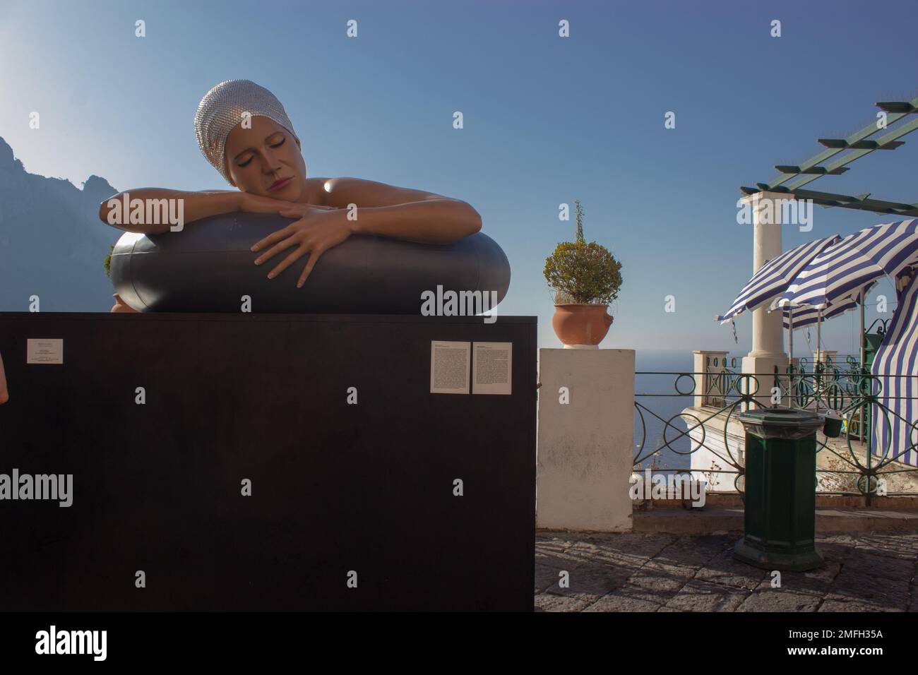 A woman, enjoying the sun on a roof balcony on Capri Island in Italy ...