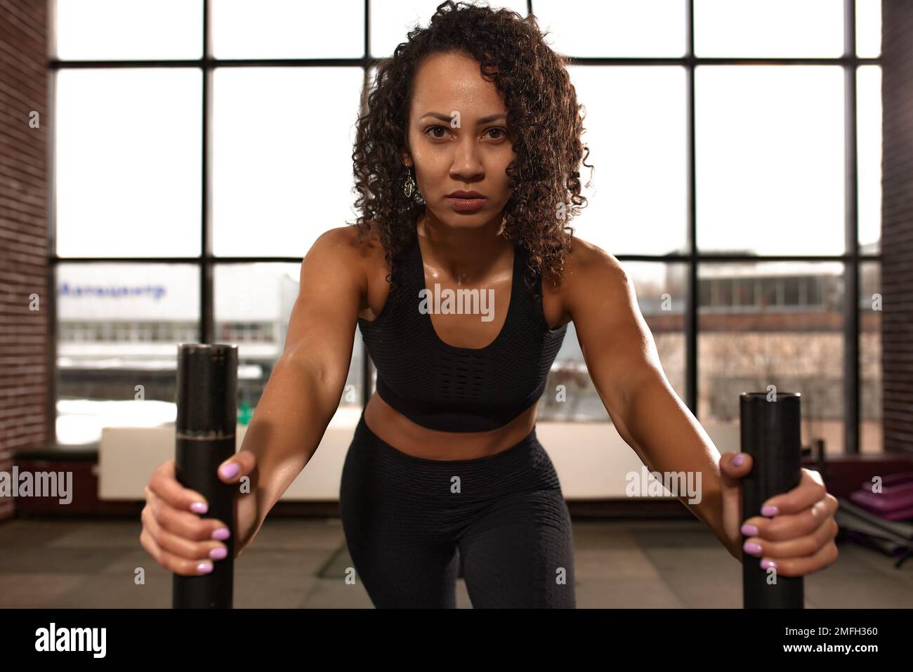 African American fitness trainer pulls a crossfit sled from the ...