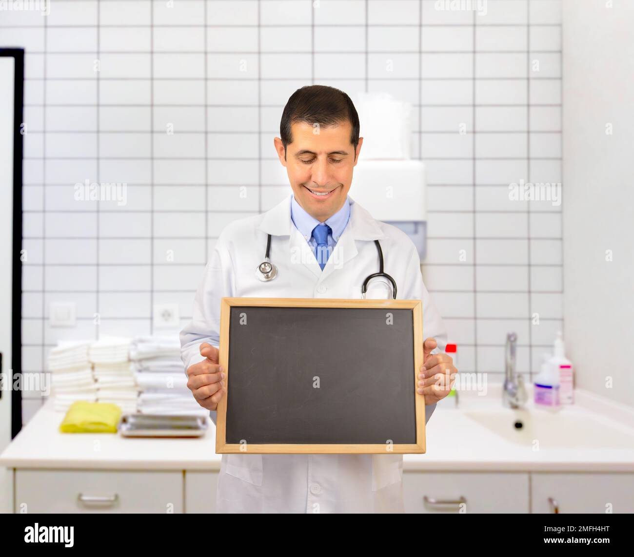 Doctor standing and looking chalkboard at hospital with copy space ...