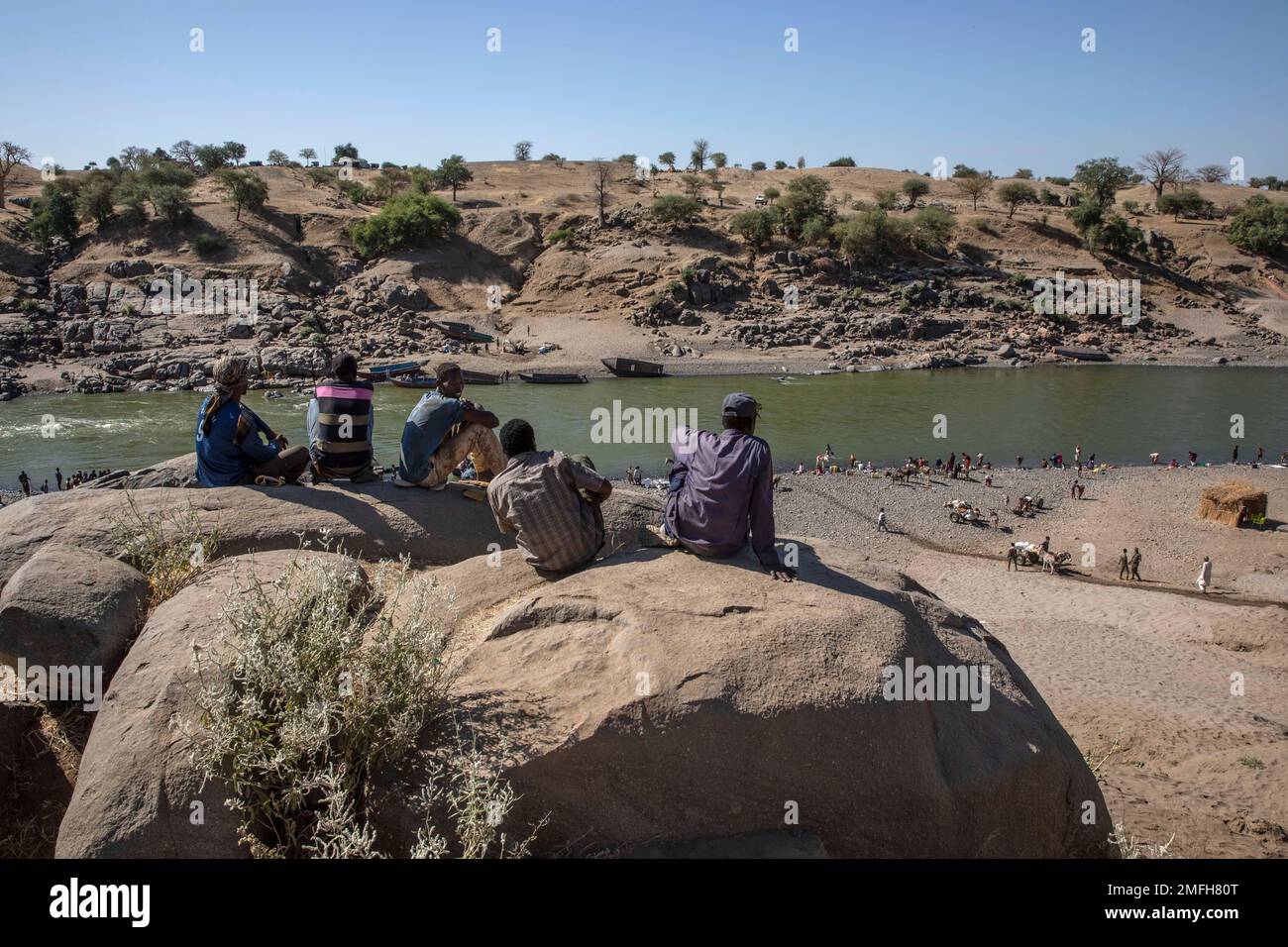 Sudanese men watch Tigray refugees who fled the conflict in the ...