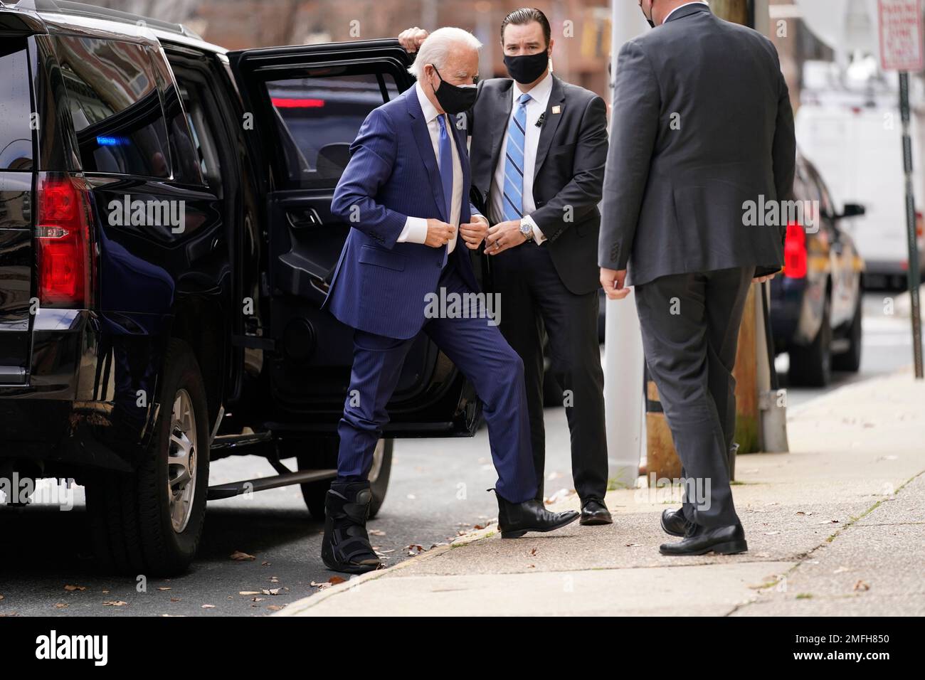 President-elect Joe Biden, wearing a medical boot, leaves his motorcade ...