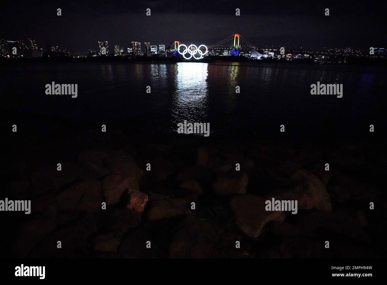 The Olympic rings float in the water with town's landmark "Rainbow ...