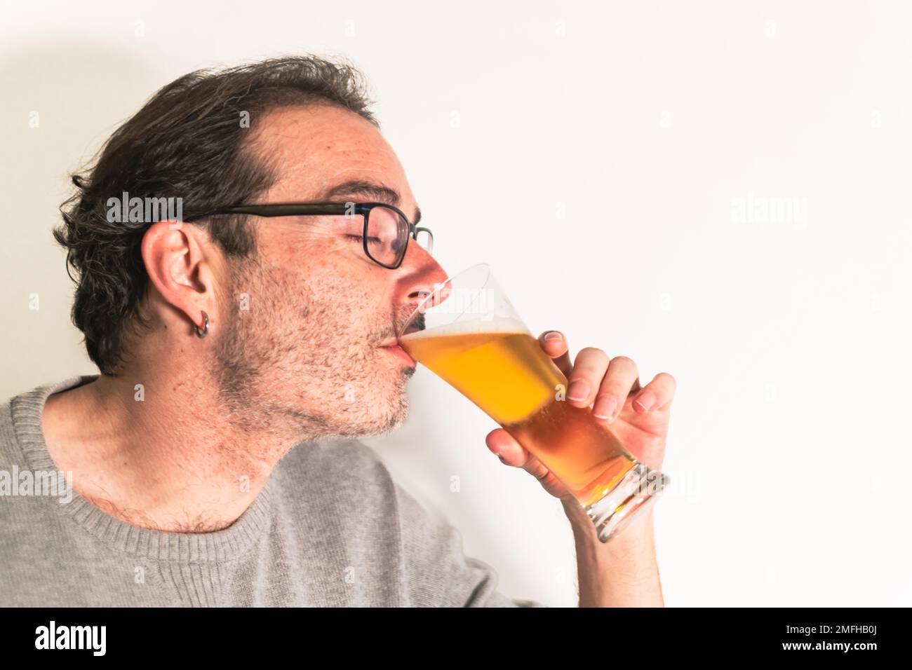 man drinking a glass of beer with his eyes closed and enjoying the ...