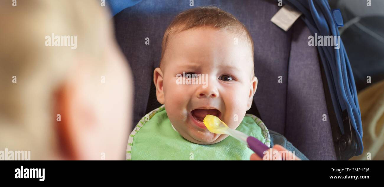 Beautiful baby boy make grimace, dont like to eat porridge food, with a ...