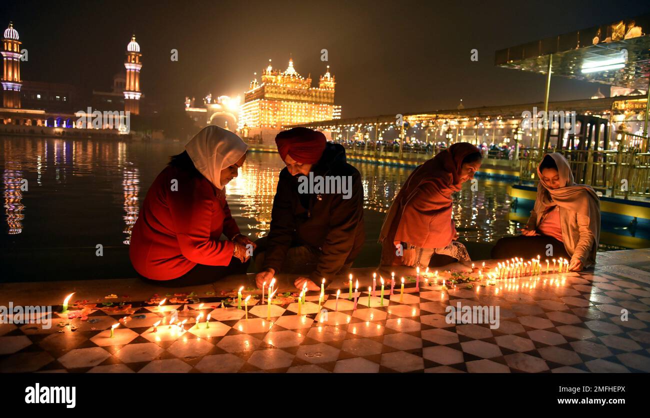 Sikh devotees light candlesin the pre-dawn hours at the illuminated ...