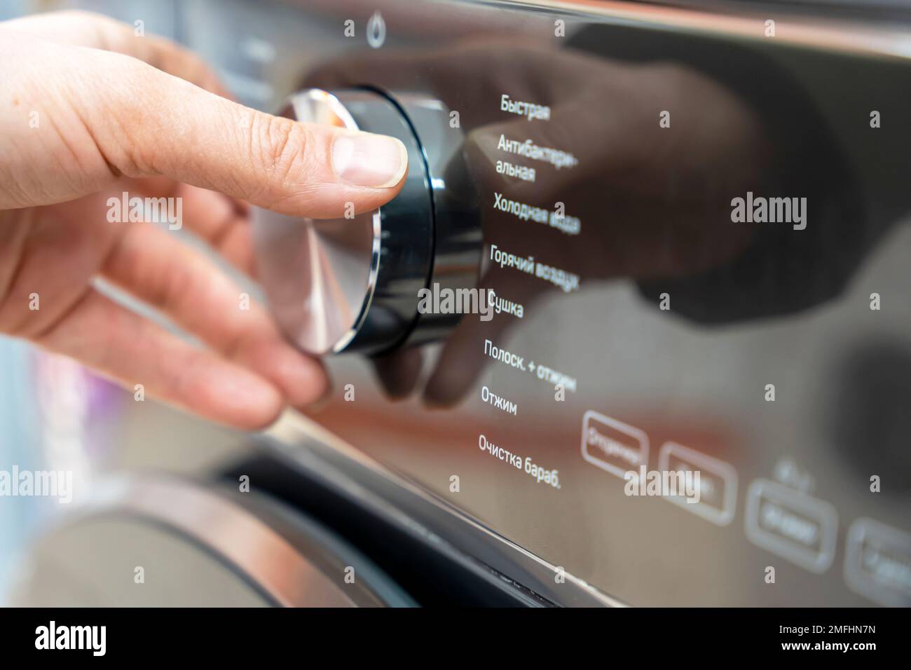 woman's hand selects the washing mode with a round selector Stock Photo ...