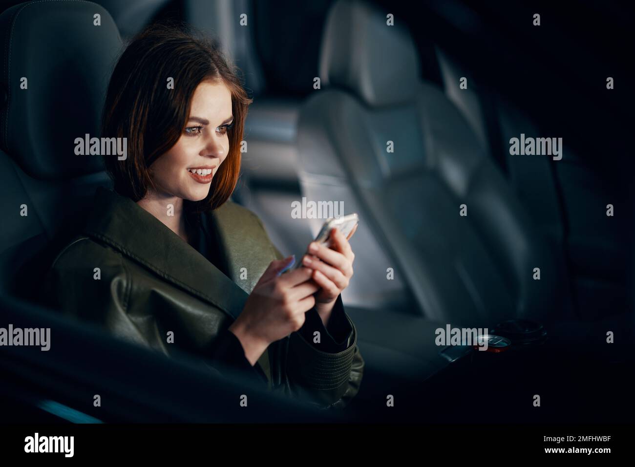 a close horizontal portrait of a stylish, luxurious woman in a leather ...