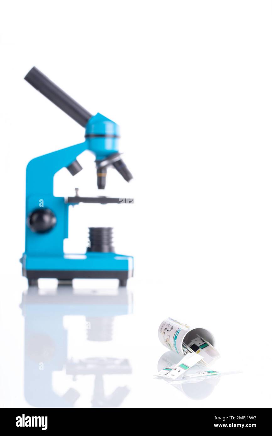 A vertical shot of diabetes test strips with a microscope in white ...