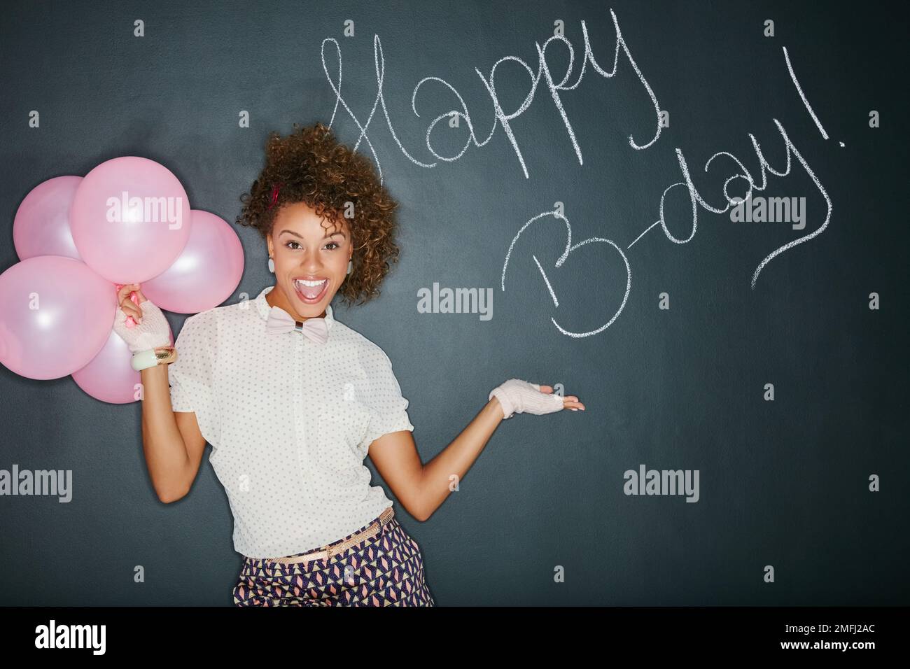 Excited, happy birthday balloons and portrait of a model and chalkboard ...
